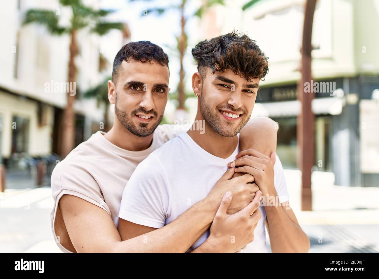 Two hispanic men couple smiling confident hugging each other standing ...