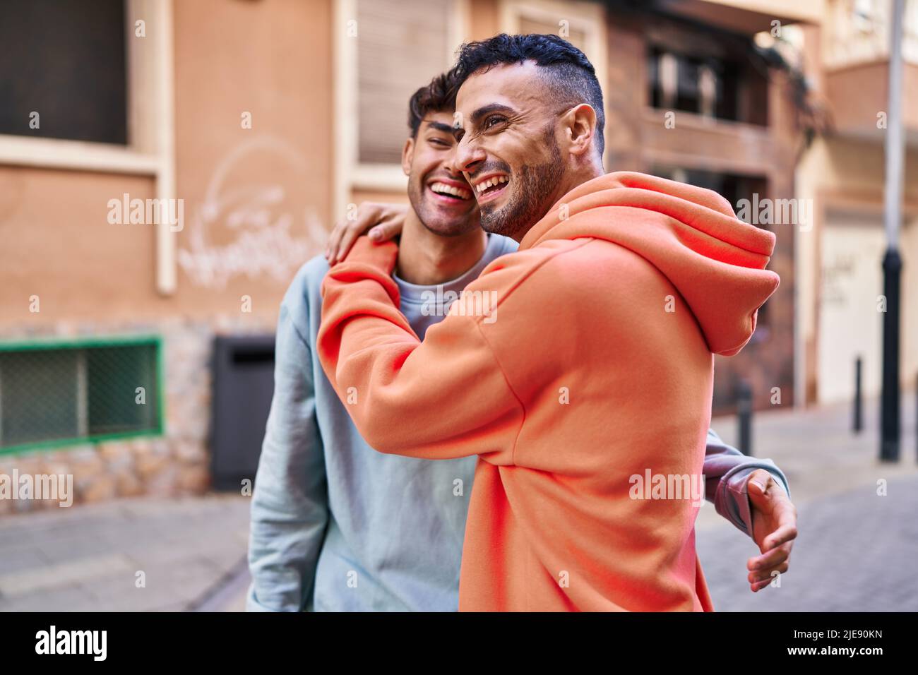 Two man couple hugging each other standing at street Stock Photo - Alamy