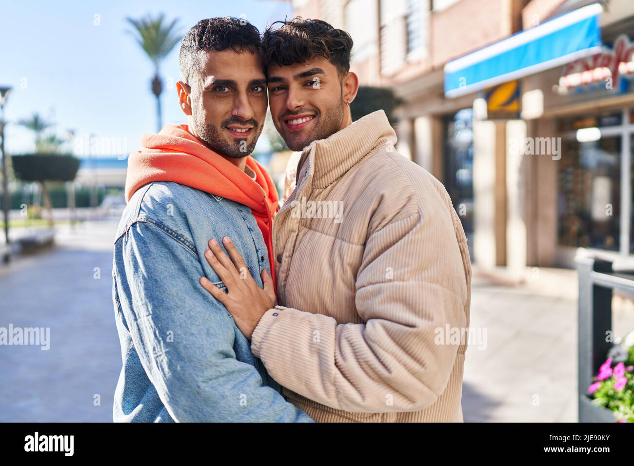 Two man couple hugging each other standing at street Stock Photo - Alamy