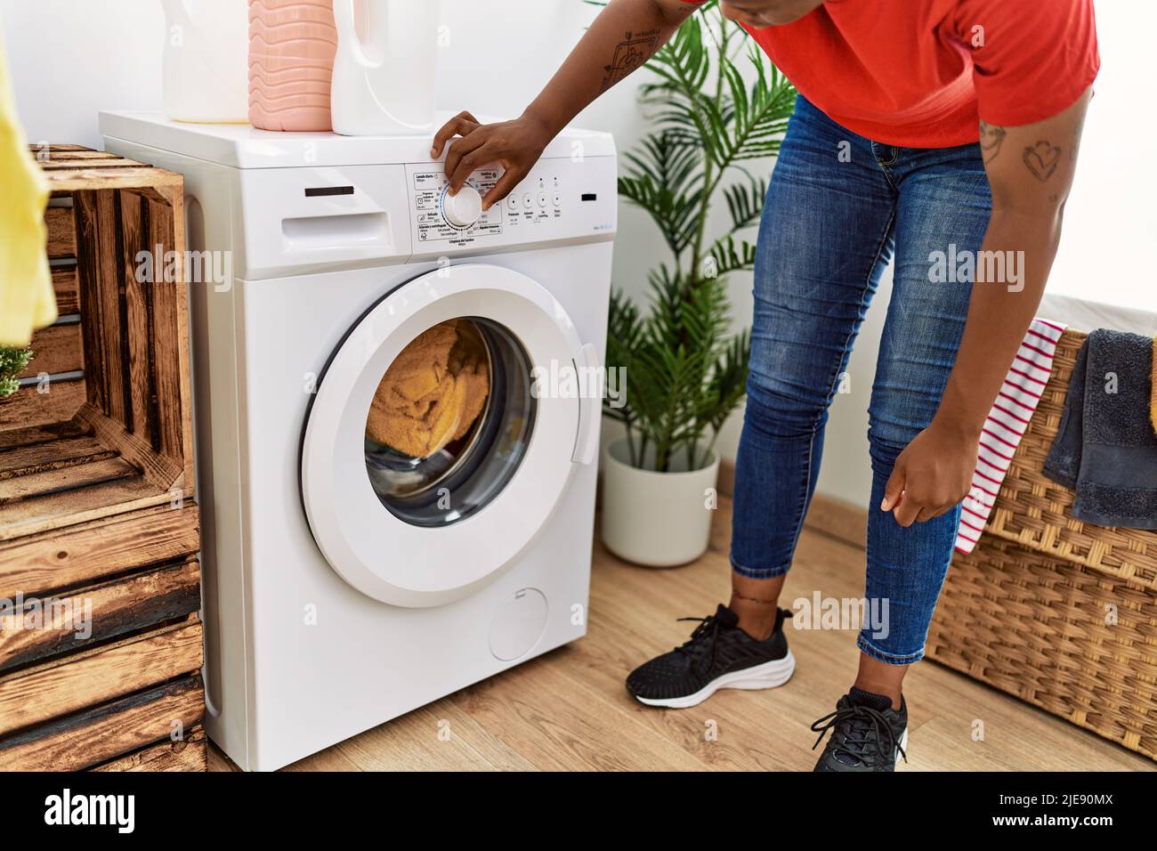 Young african man setting washing machine at laundry room Stock Photo ...