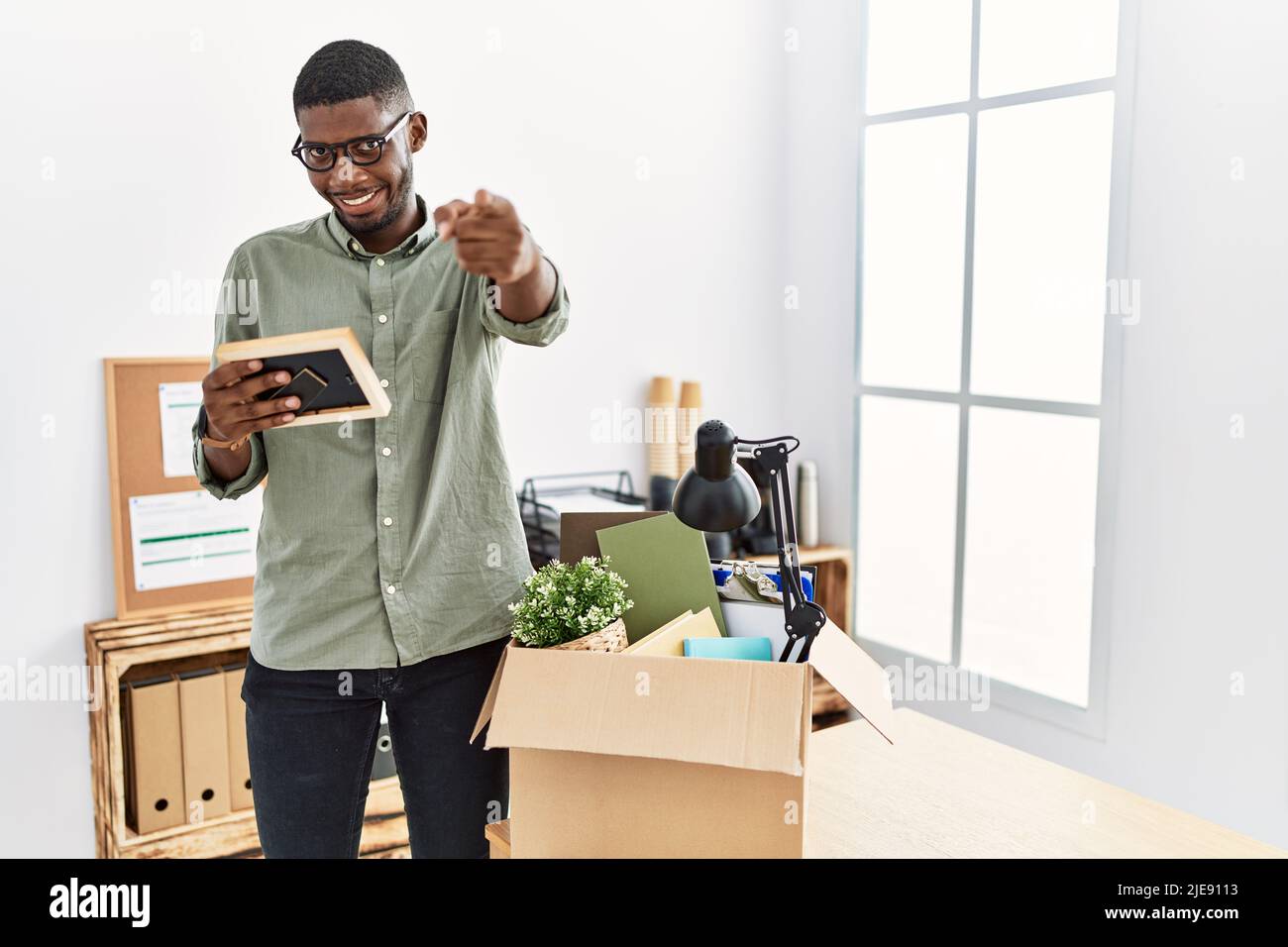 Young african american businessman unboxing box at the office pointing ...