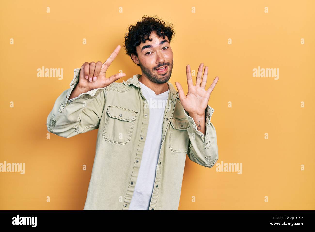 Young hispanic man wearing casual clothes showing and pointing up with ...