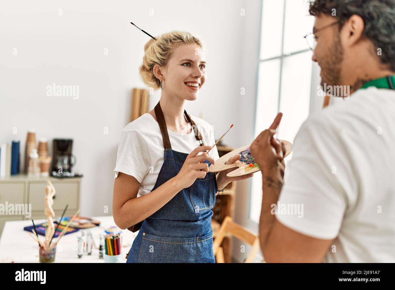 Young artist couple smiling happy speaking at art studio Stock Photo ...