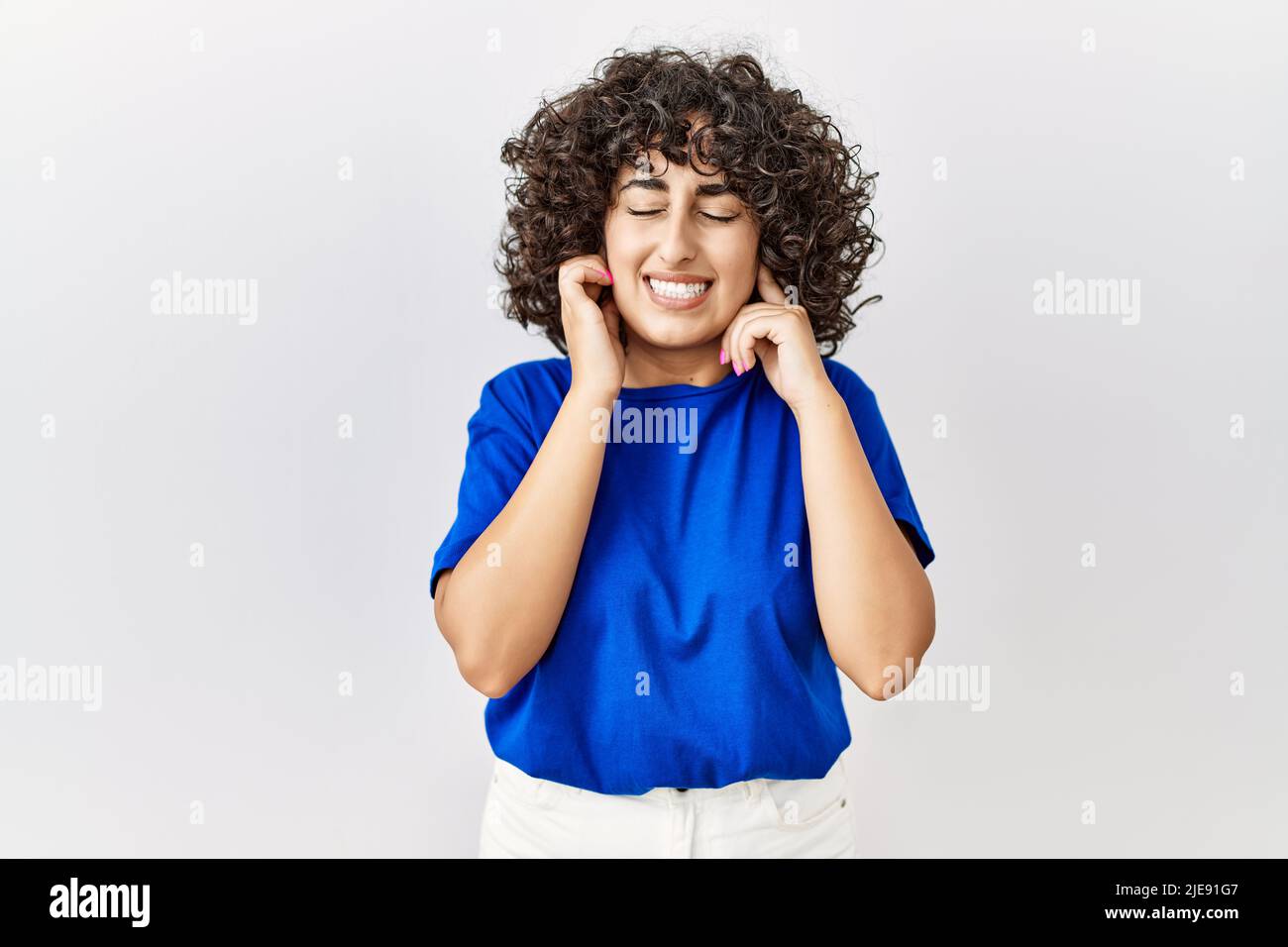 Young middle eastern woman standing over isolated background covering ...