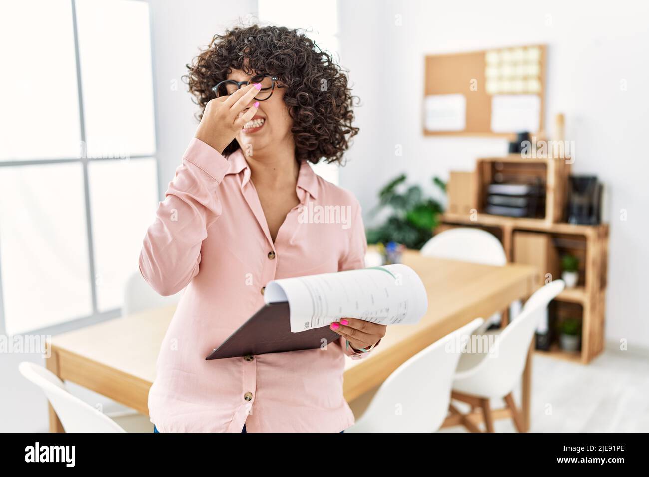 Young middle eastern woman wearing business style at office smelling ...