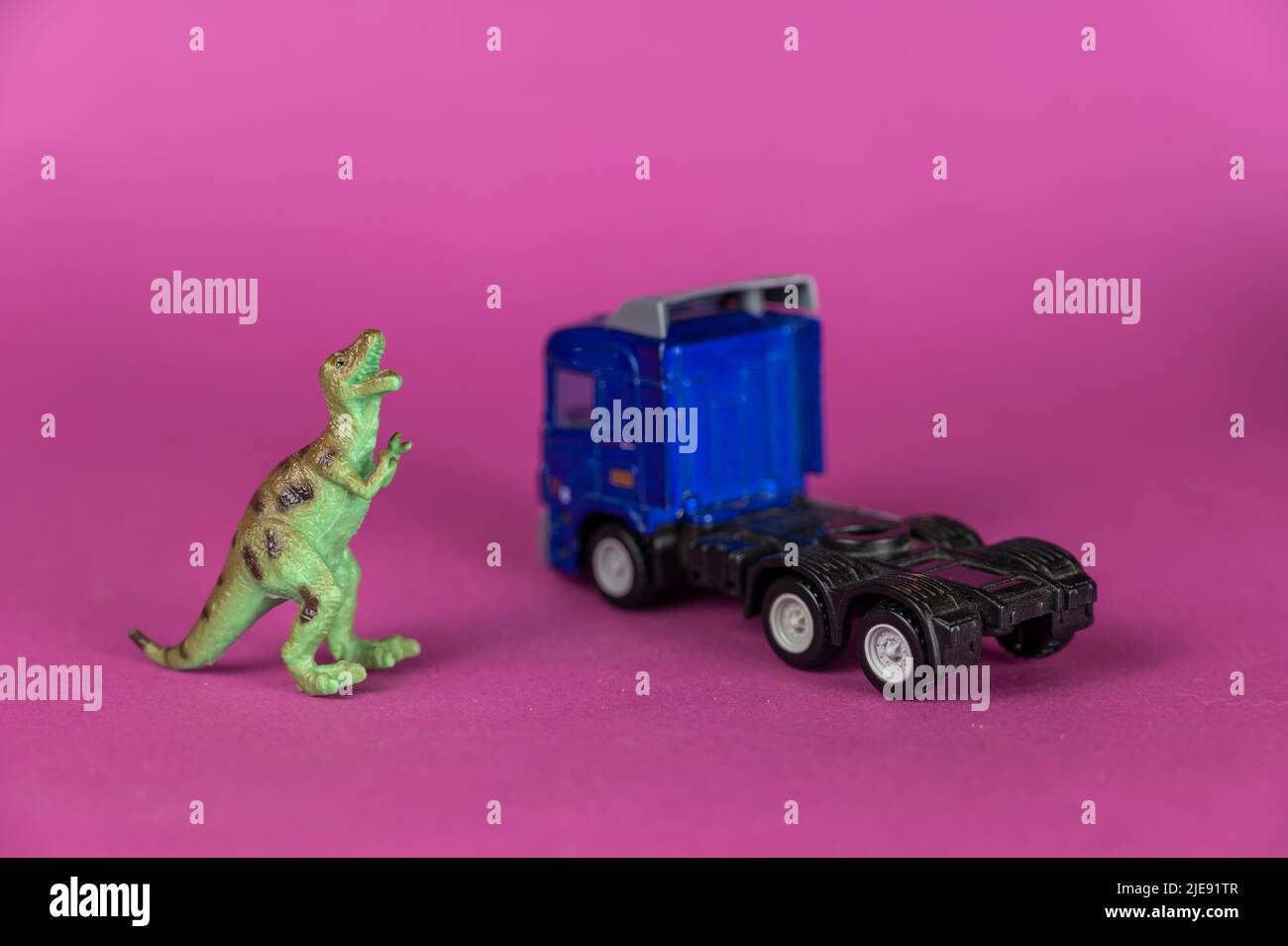 Dinosaur and tractor-trailer against a purple background. Green plastic ...