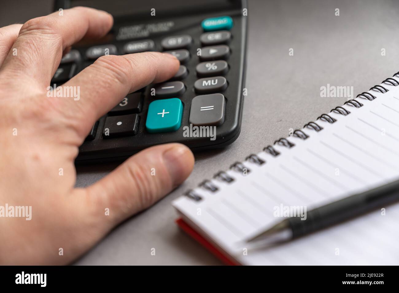 Close-up of a man's hand doing calculations on a calculator. The index ...