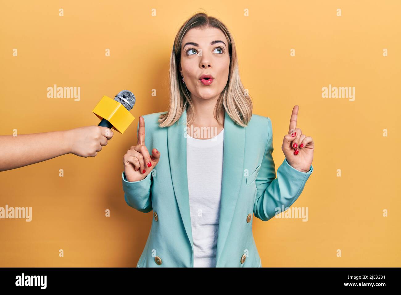 Beautiful caucasian woman being interviewed by reporter holding ...