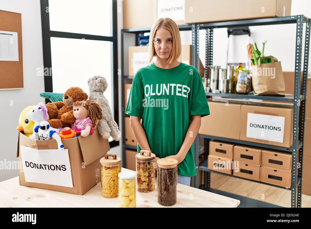 Young caucasian woman wearing volunteer t shirt at donations stand ...