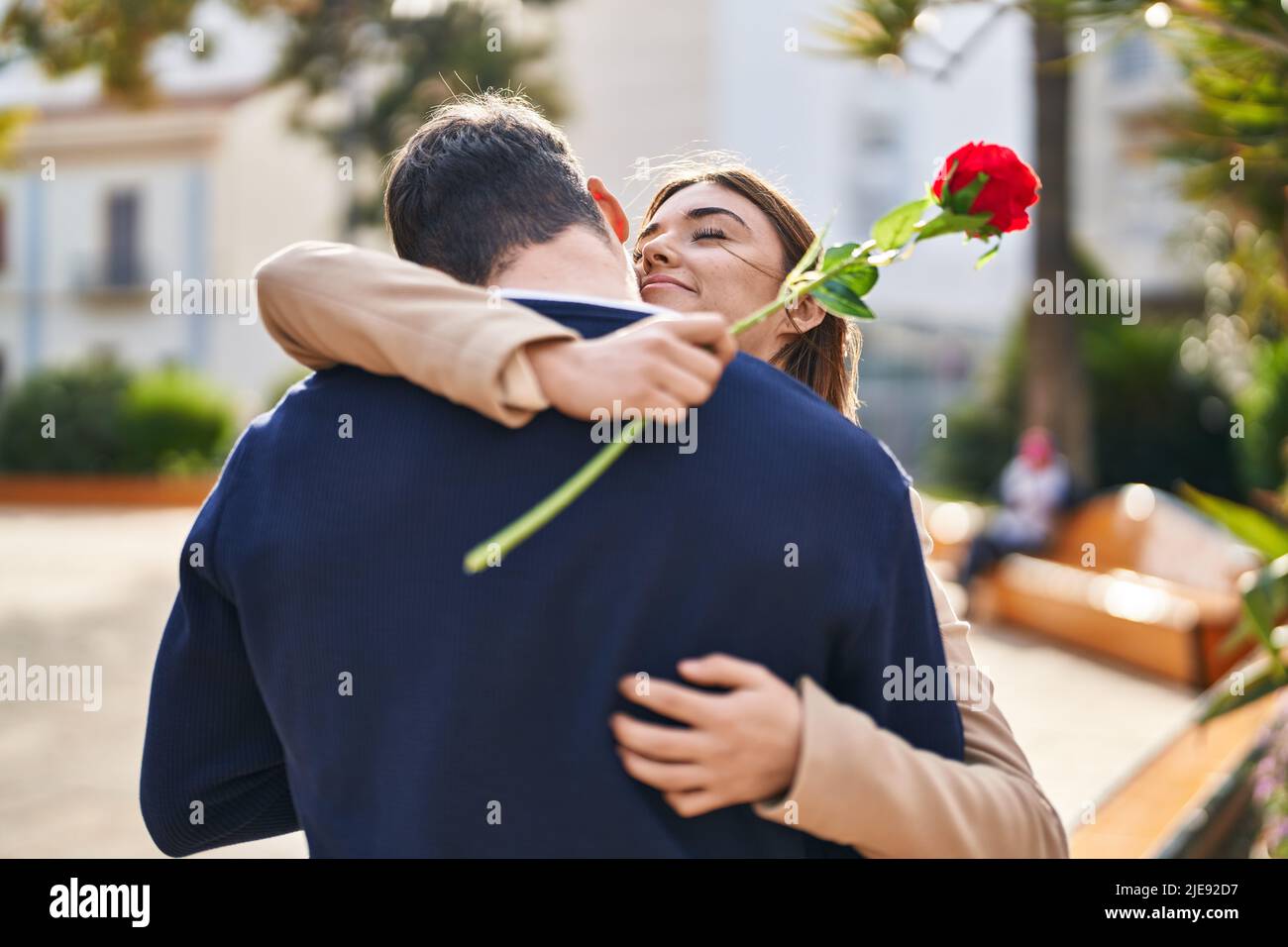 Mand and woman couple hugging each other suprise with rose at park ...