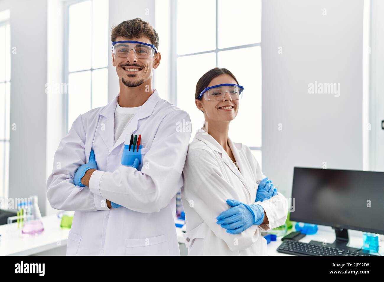Man and woman partners wearing scientist uniform standing with arms ...