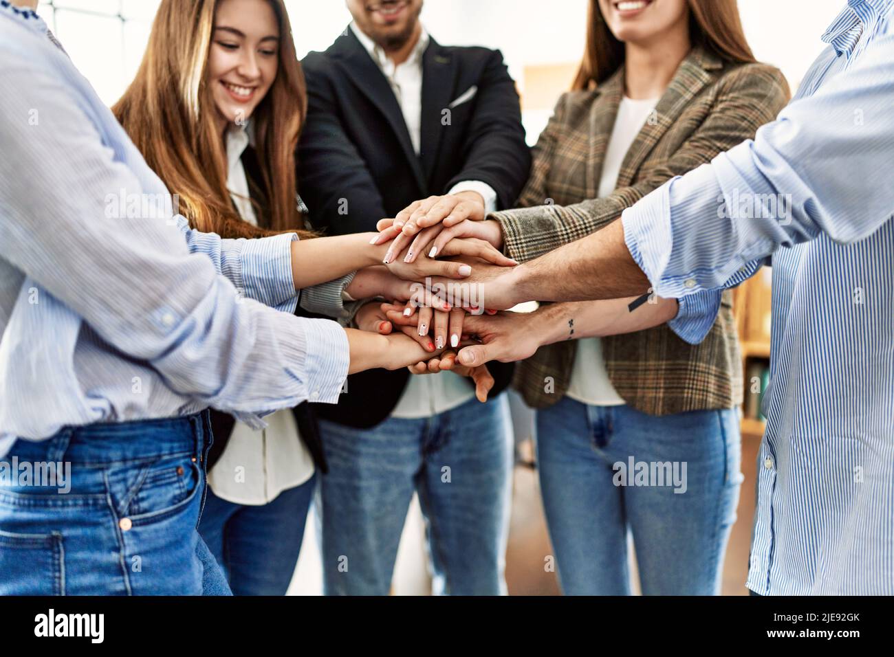 Group of business workers smiling happy standing with hands together at ...