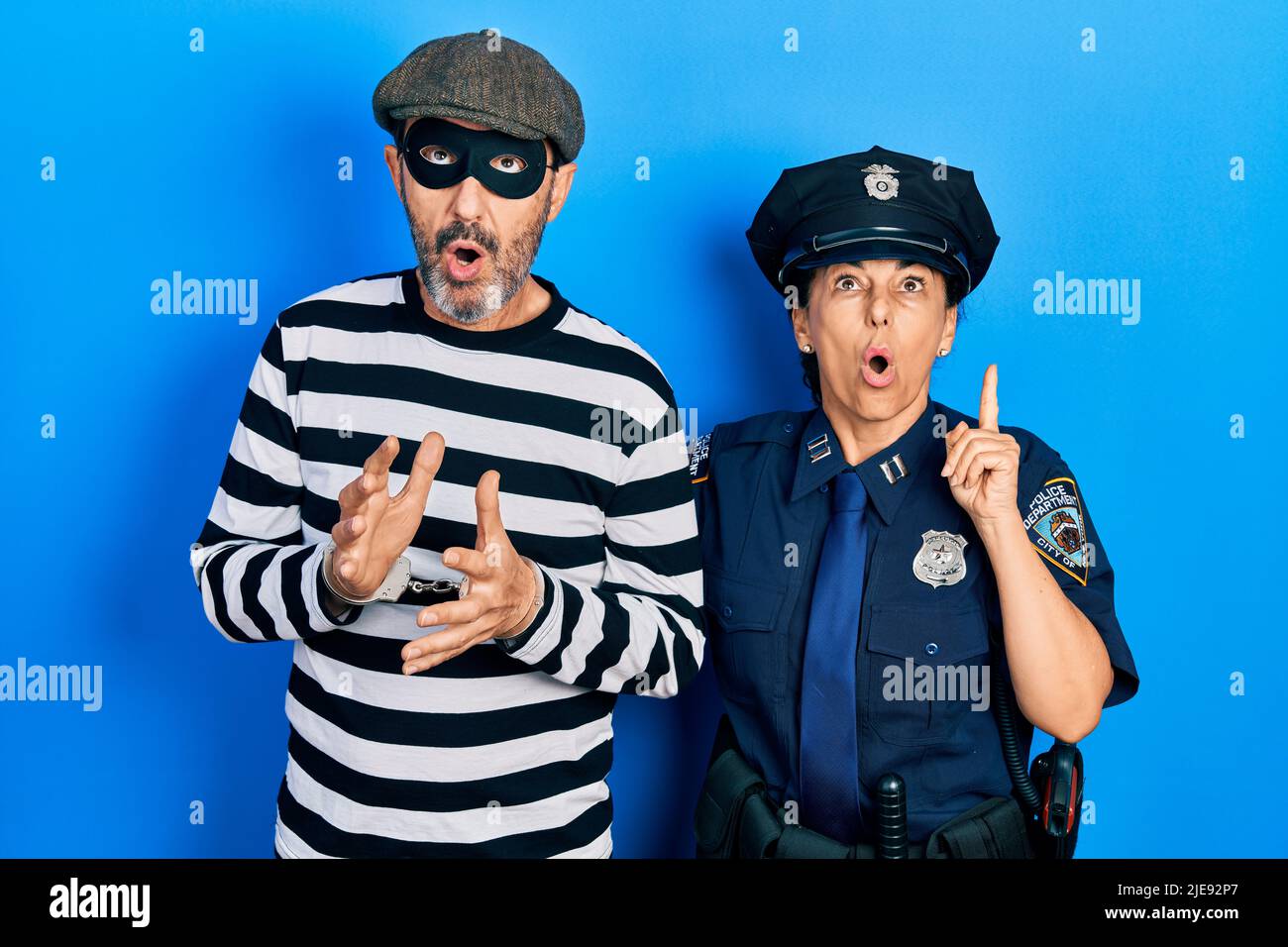 Middle age couple of hispanic woman and man wearing thief and police ...