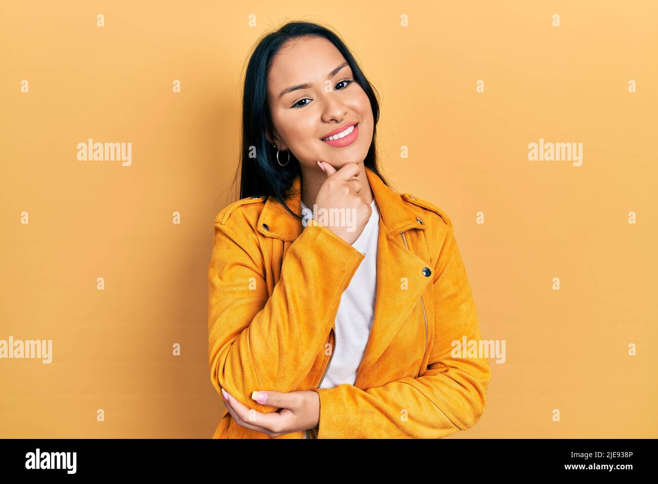 Beautiful hispanic woman with nose piercing wearing yellow leather ...