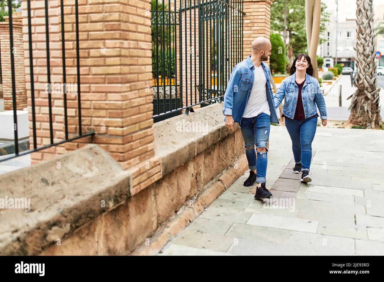 Young hispanic couple smiling happy walking with hands together at the ...