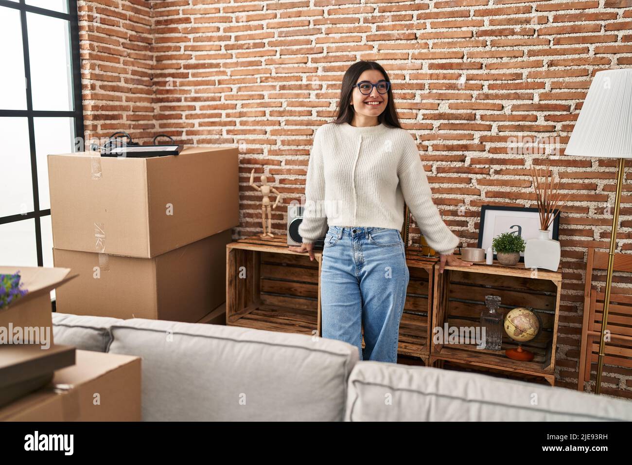 Young hispanic woman smiling confident standing at new home Stock Photo ...