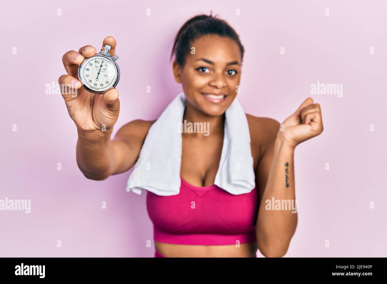 Young african american girl wearing sportswear holding stopwatch ...