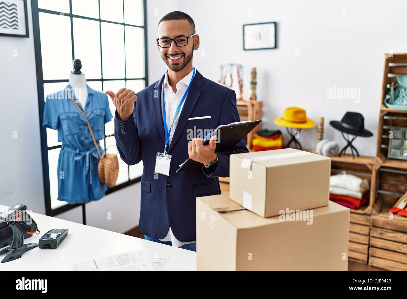 African american man working as manager at retail boutique pointing to ...