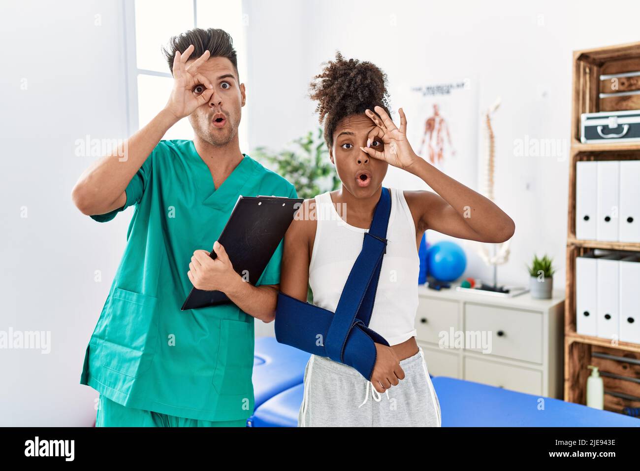 Physiotherapist working with patient wearing arm on sling at ...