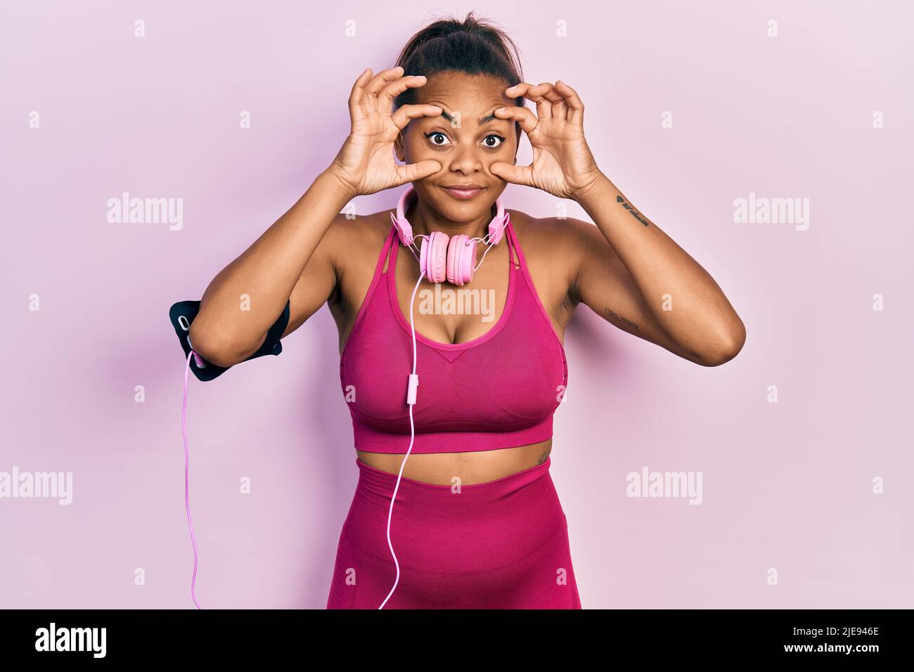 Young african american girl wearing gym clothes and using headphones ...