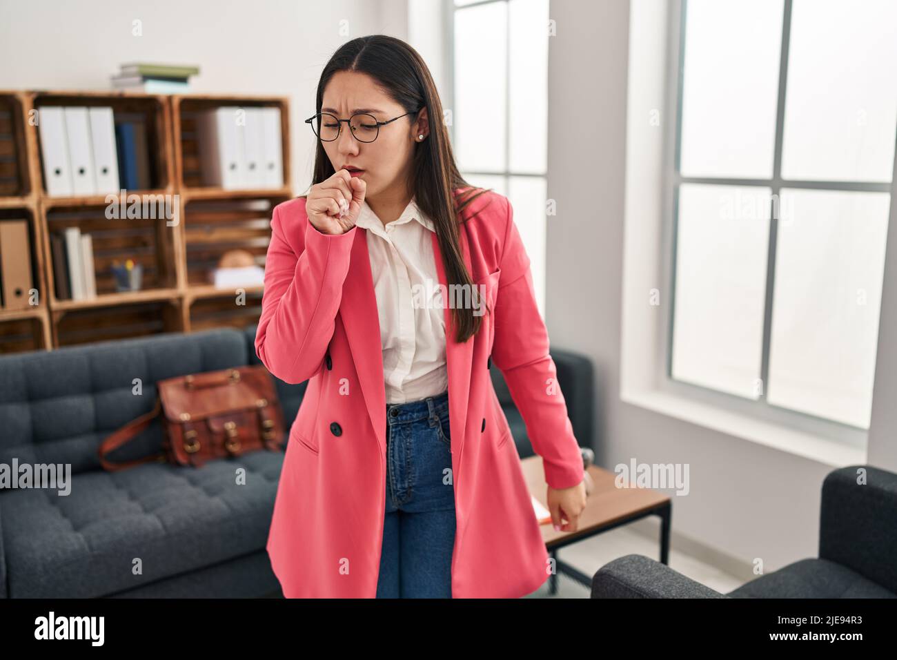Young latin woman working at consultation office feeling unwell and ...