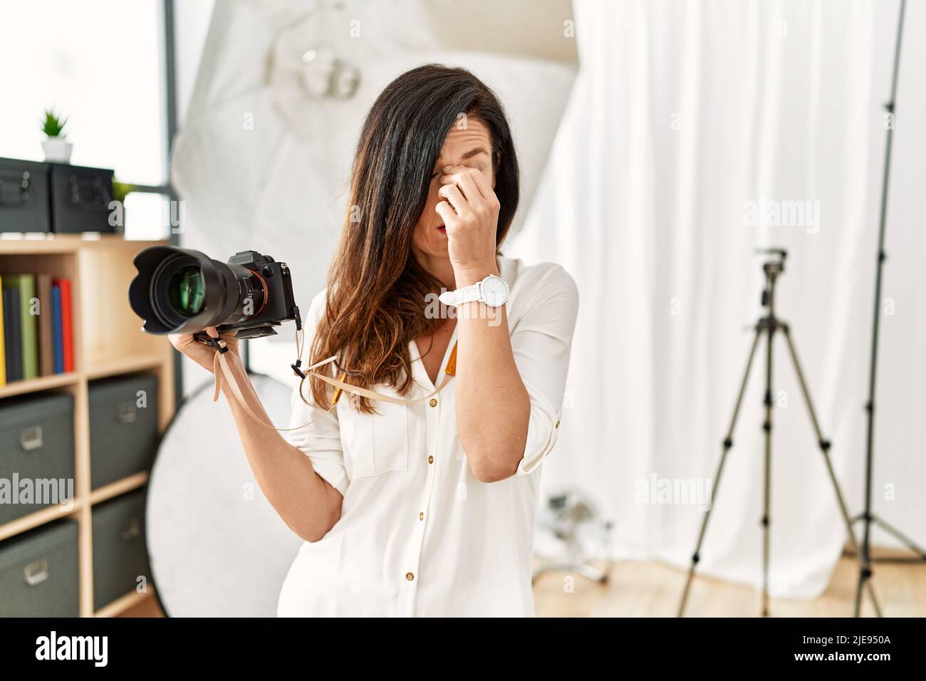 Beautiful caucasian woman working as photographer at photography studio ...