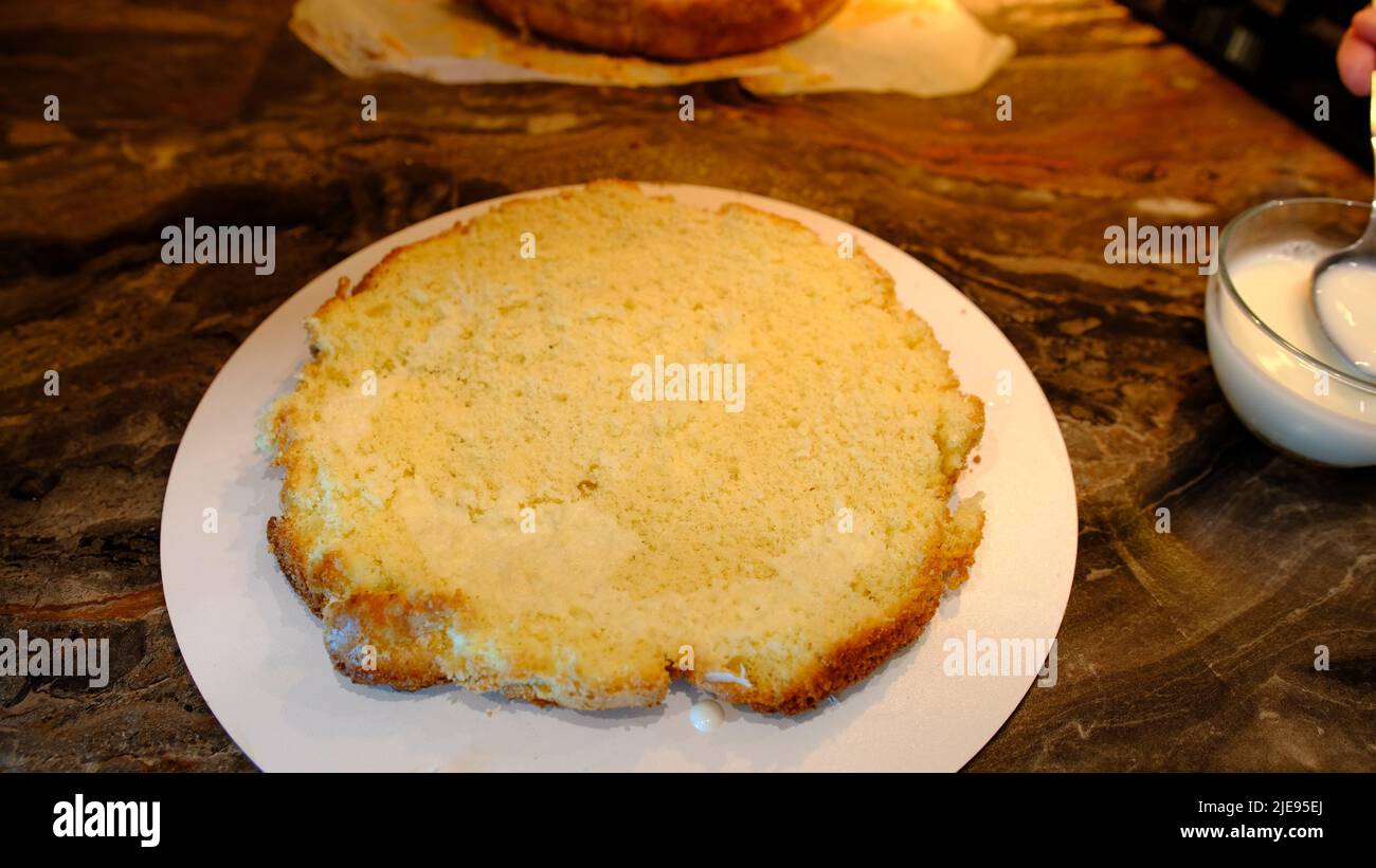 close-up of man making a cake. impregnation of sponge cake with milk ...