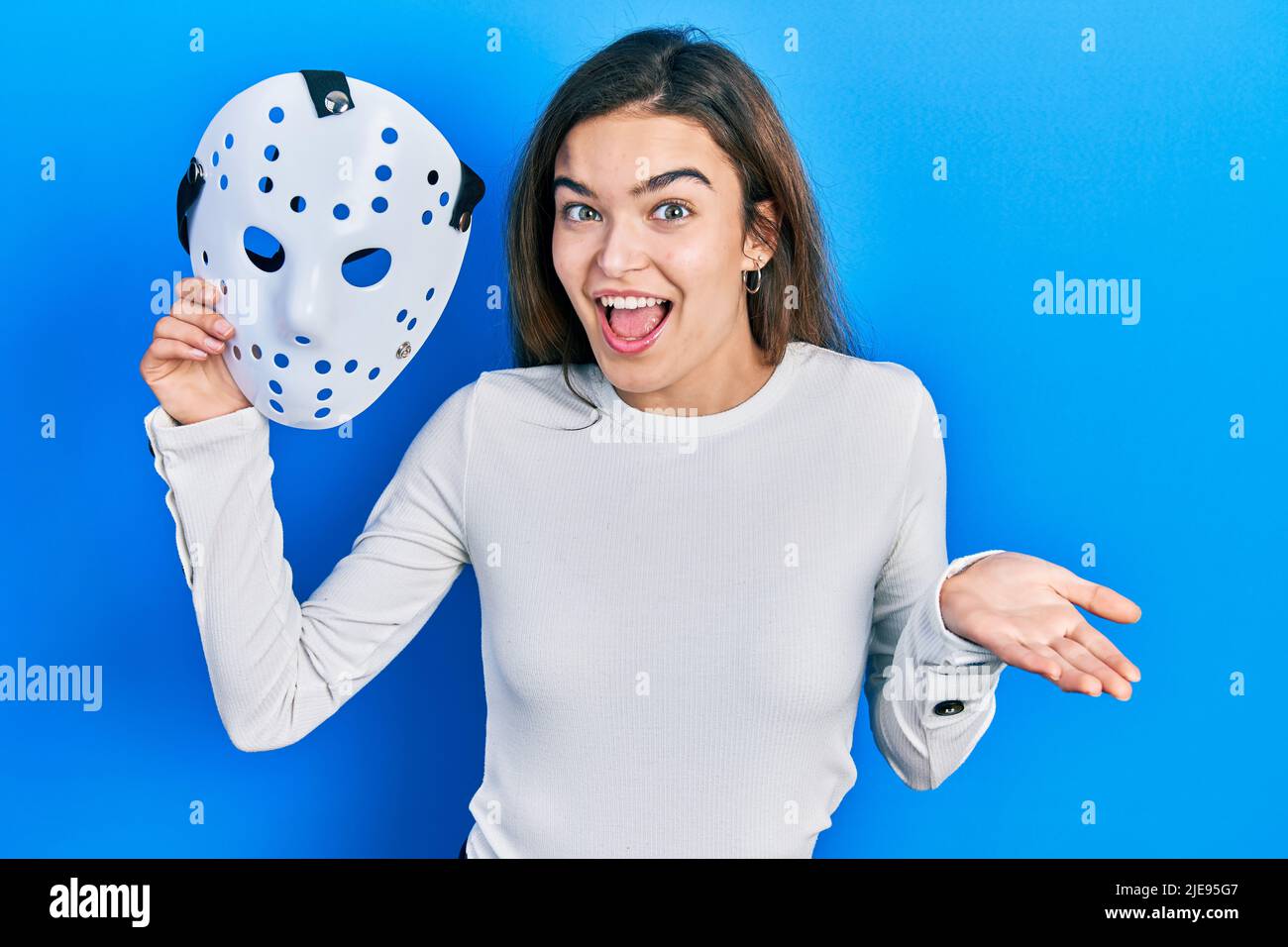 Young caucasian girl holding hockey mask celebrating achievement with ...