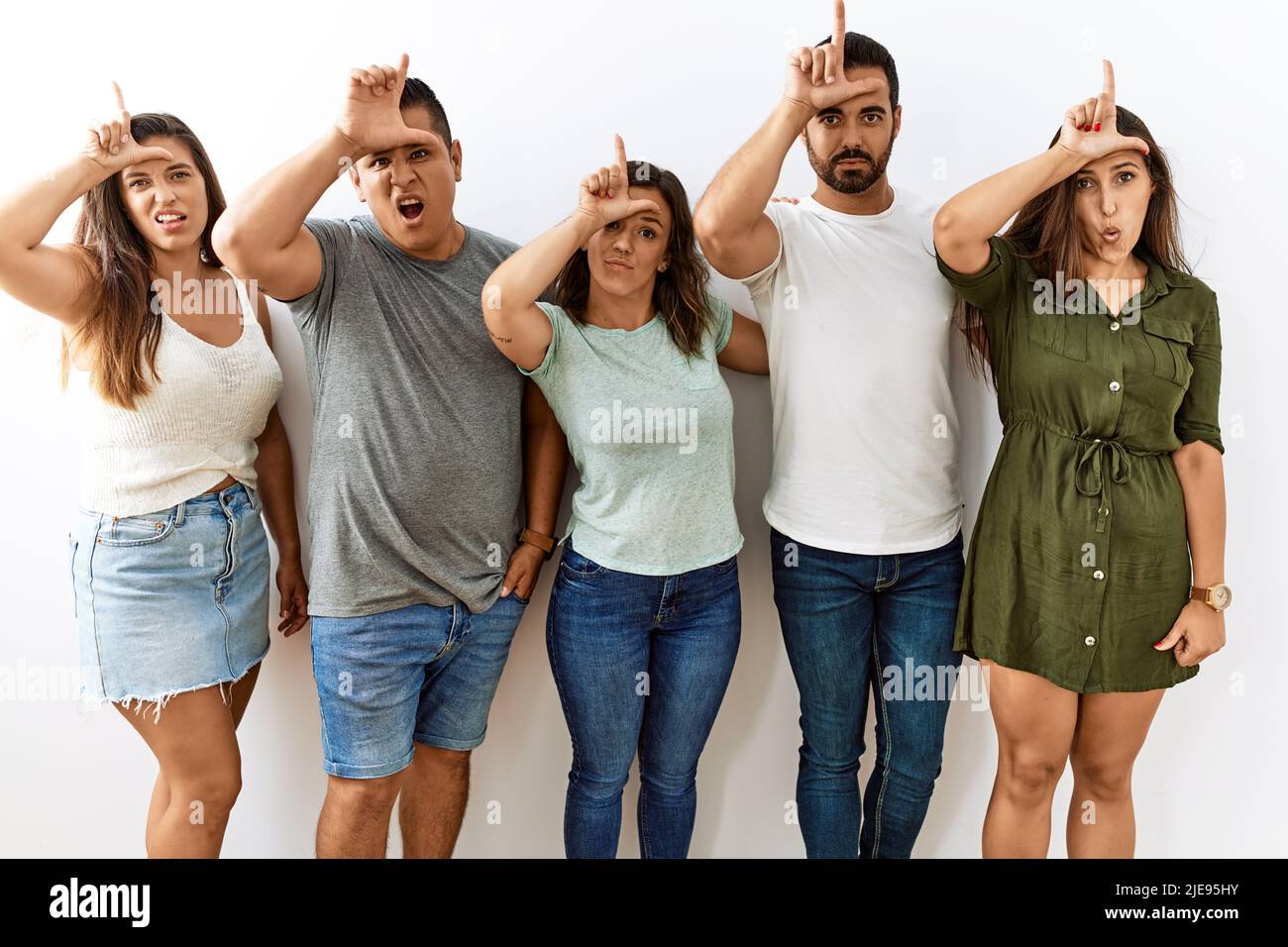Group of young hispanic friends standing together over isolated ...