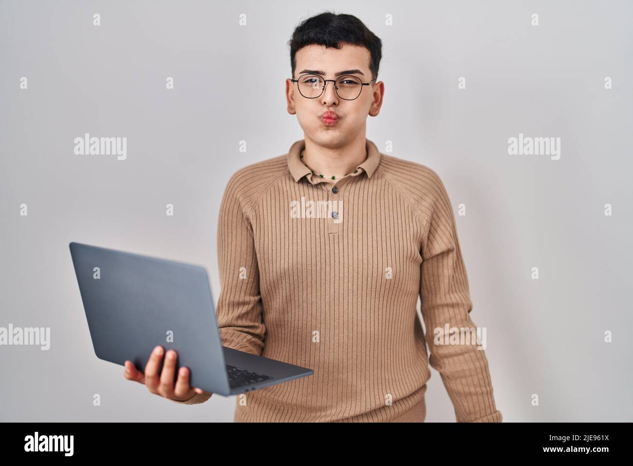 Non binary person using computer laptop puffing cheeks with funny face ... Non binary person using computer laptop puffing cheeks with funny face ...