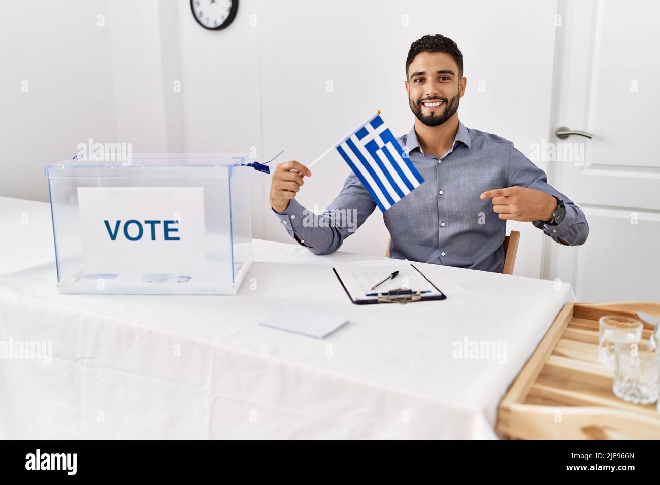 Young handsome man with beard at political campaign election holding ...