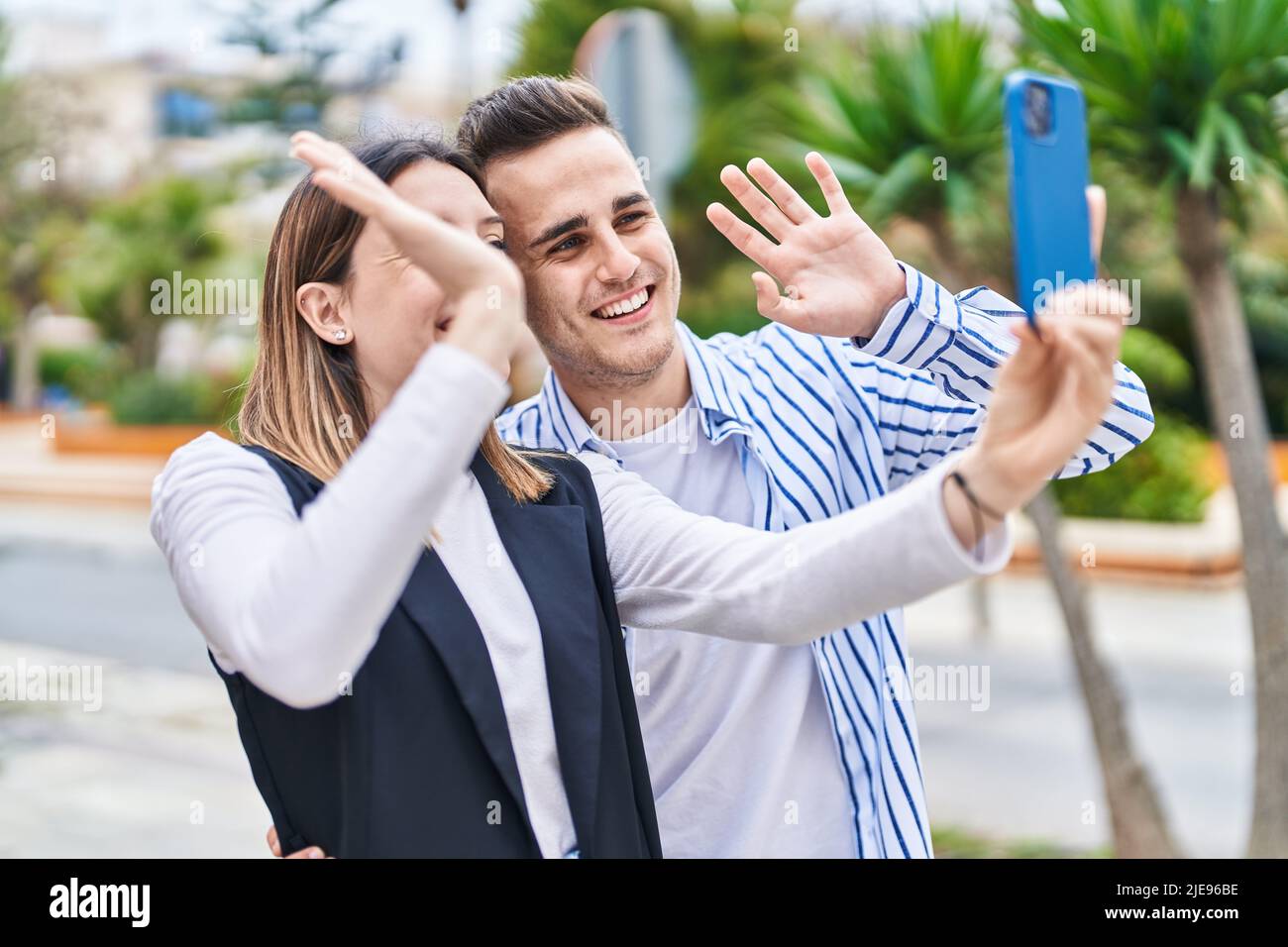 Man and woman couple hugging each other having video call at street ...
