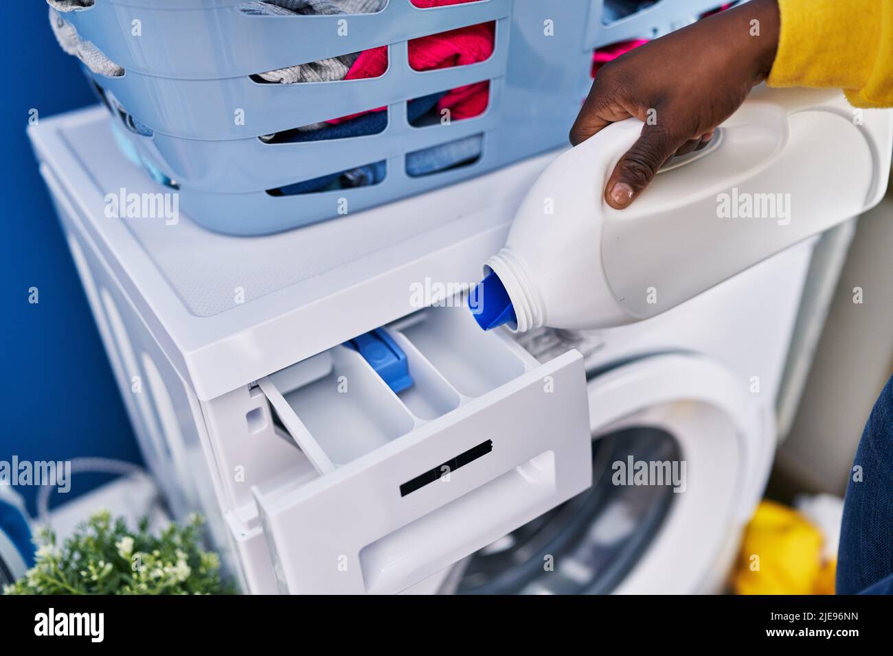 African american woman pouring detergent on washing machine at laundry ...