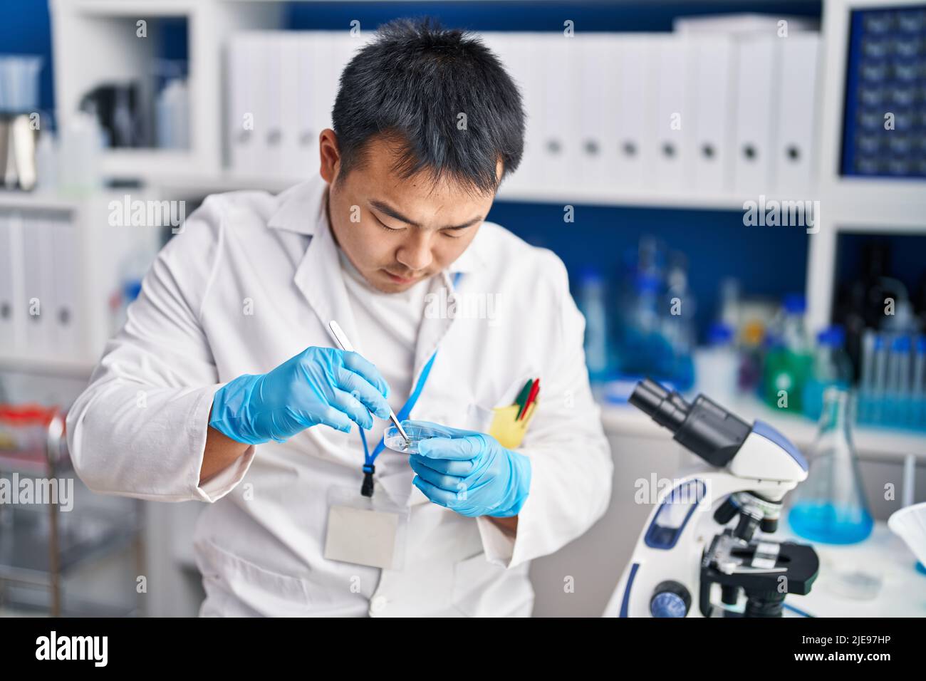 Young chinese man wearing scientist uniform working at laboratory Stock ...