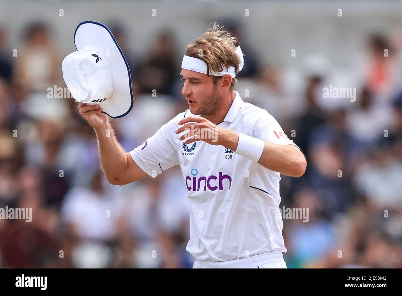 Stuart Broad of England takes his hat off to bowl Stock Photo - Alamy