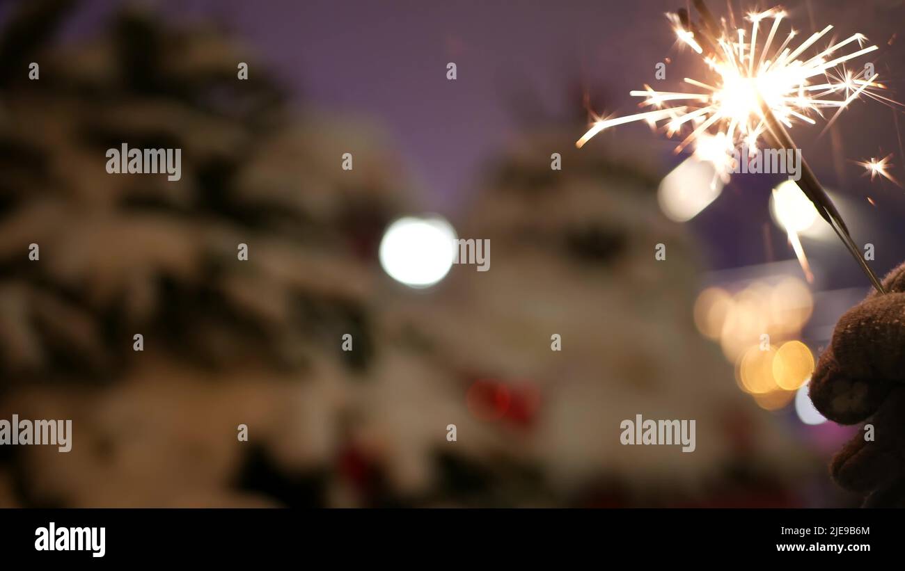 Sparkler firework burning, Christmas tree in snow, New Year or Xmas ...