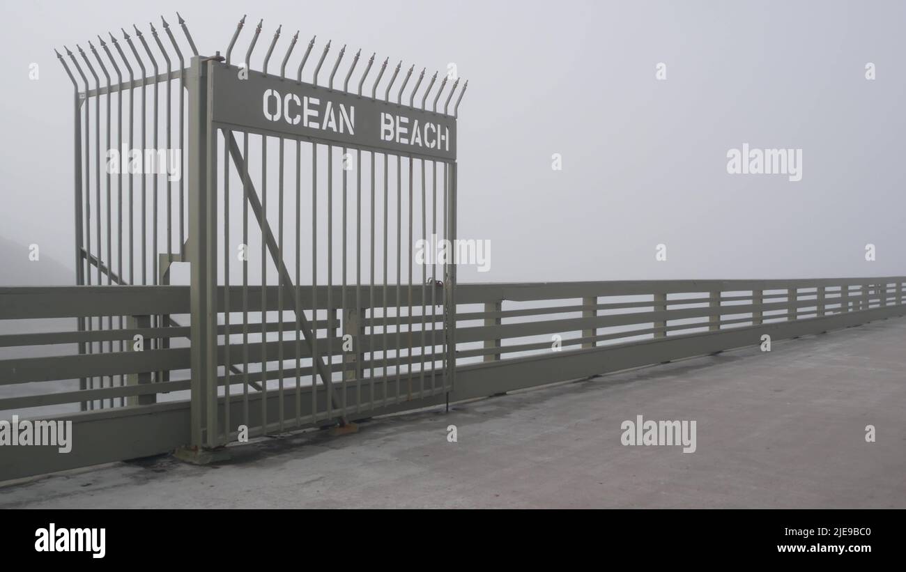Metal gate on Ocean Beach pier in fog, misty California coast, USA ...