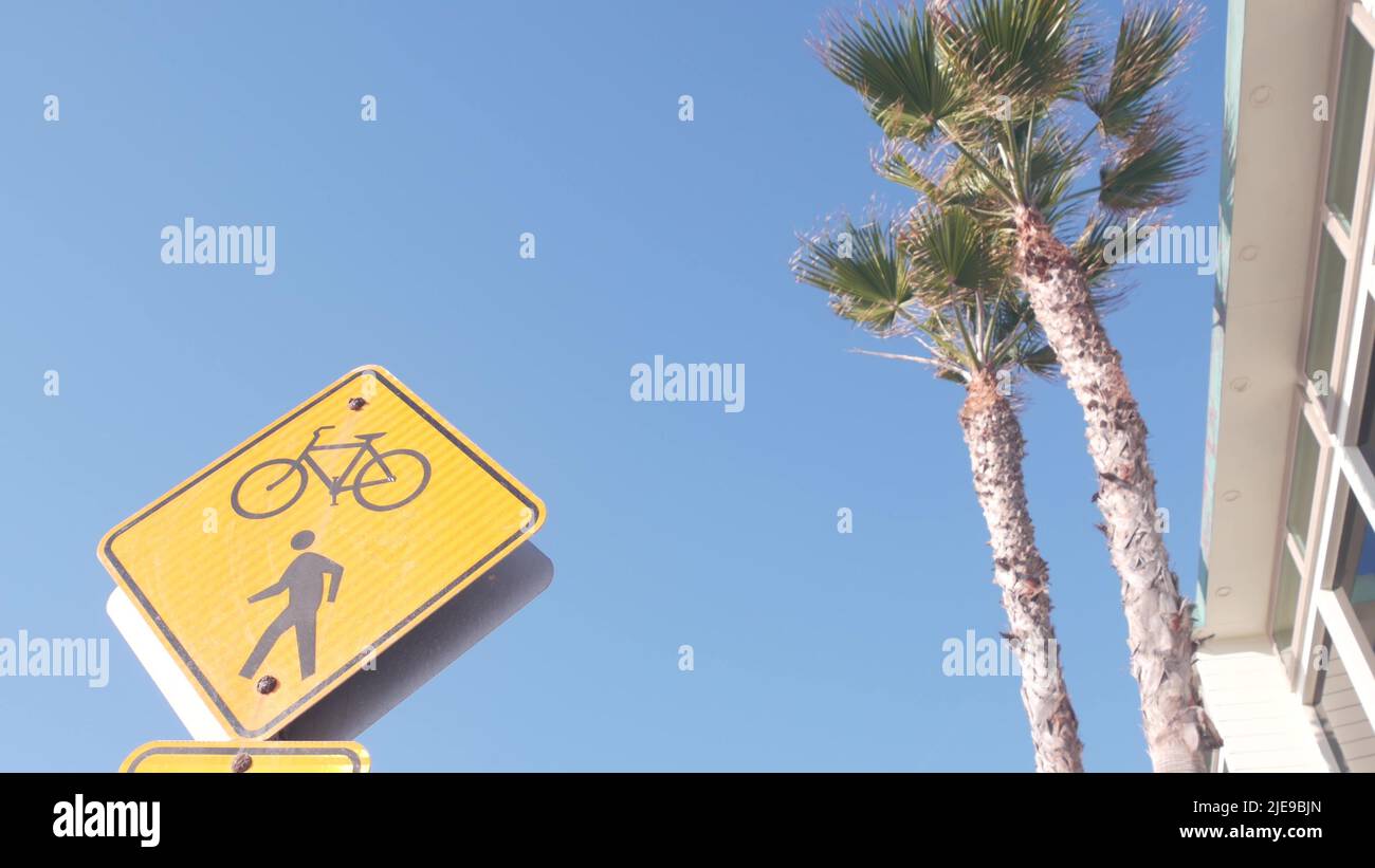 Pedestrian and bike crossing warning yellow road sign on city street ...