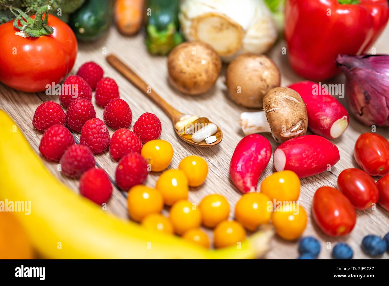 A wooden spoon with food supplements is placed in the middel of fresh ...