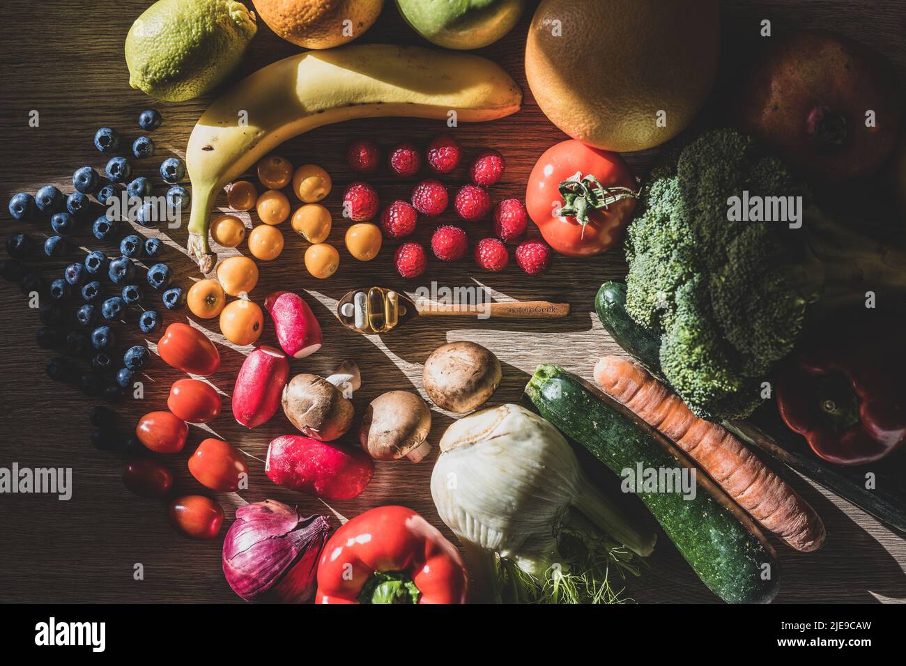 A wooden spoon with food supplements is placed in the middel of fresh ...