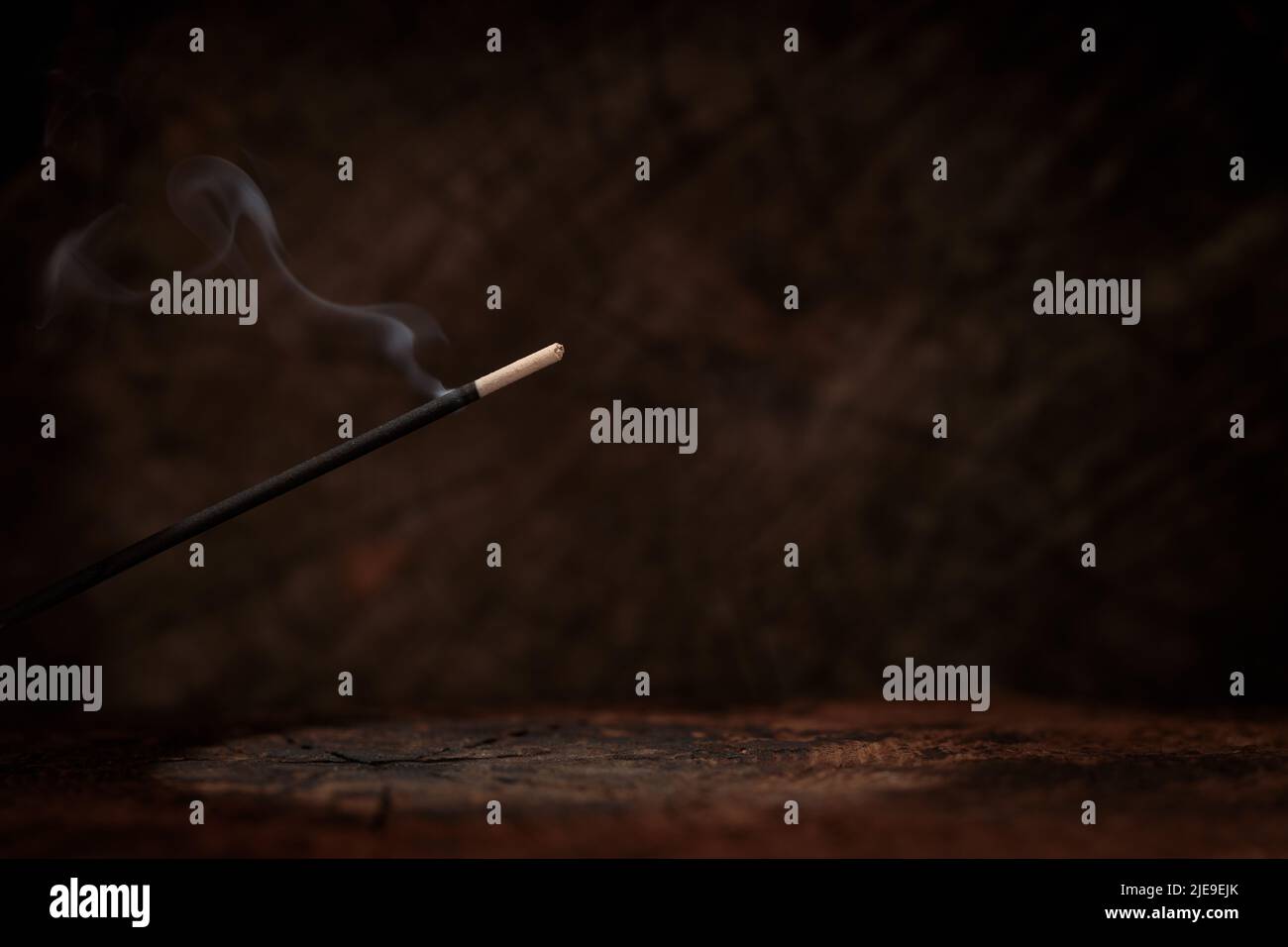 Lit incense on rustic dark wood background. Spiritual atmosphere, space ...