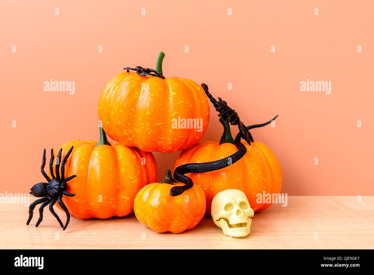 Composition of pumpkins, spiders and snakes with a human skull ...