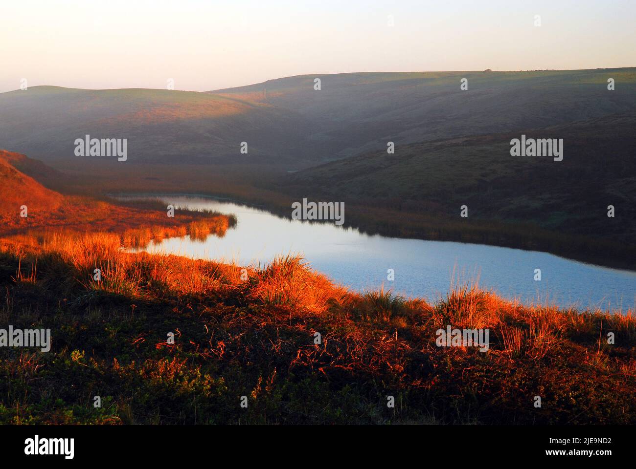 The first rays of light strike the hills overlooking Drake’s Bay in ...