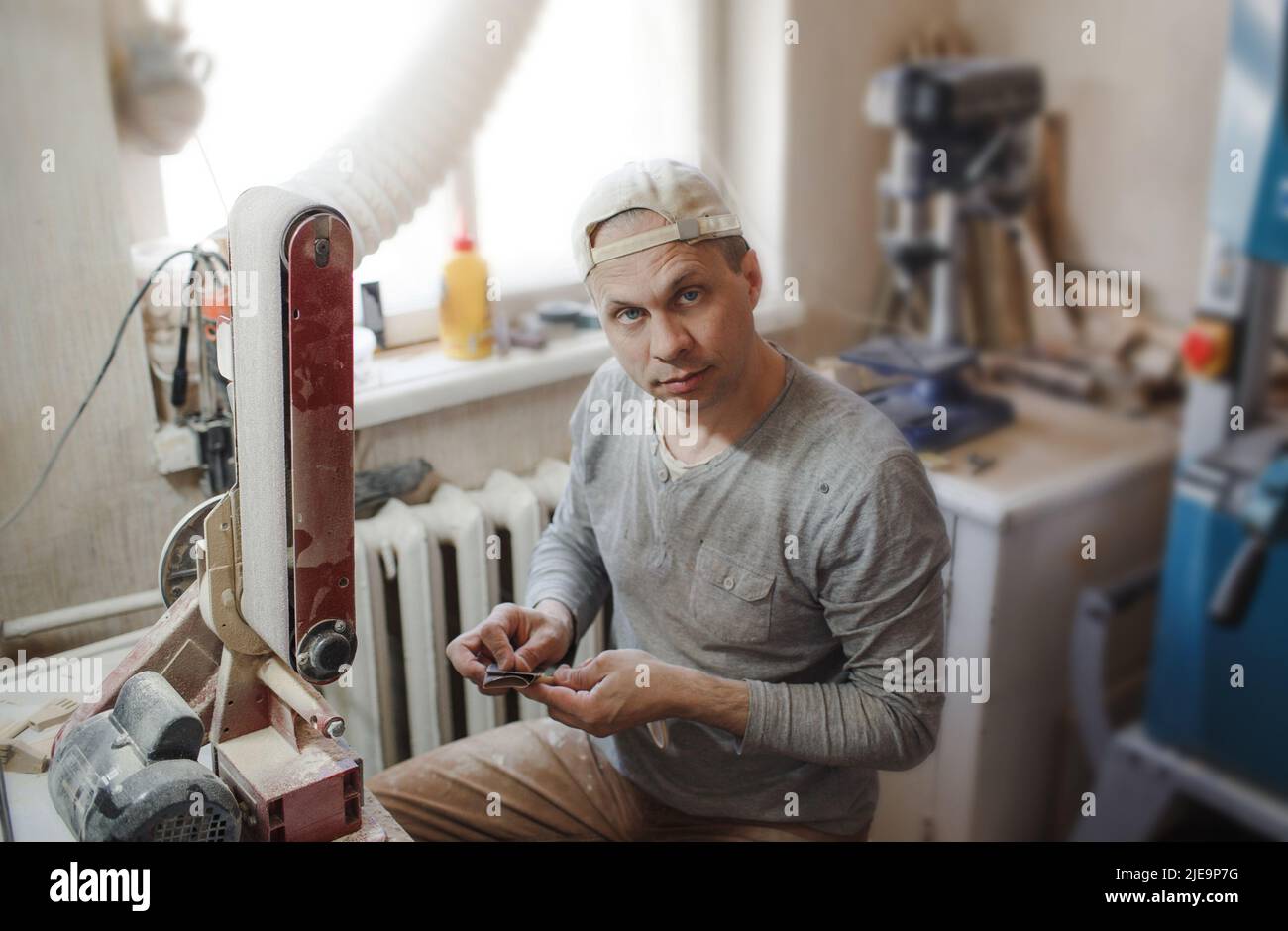 a male craftsman makes children's wooden toys in a carpentry workshop ...