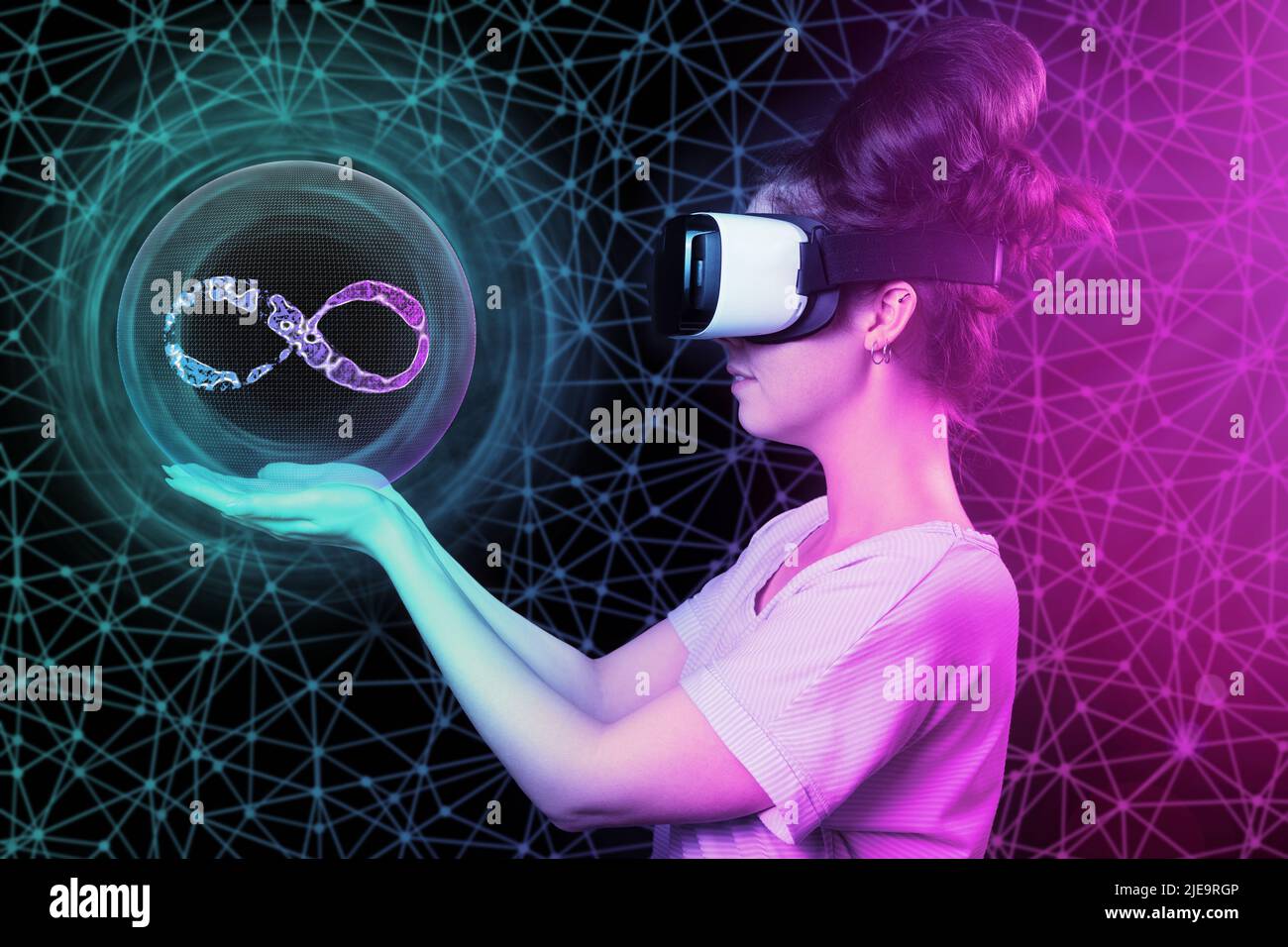 A young woman in VR glasses holding sphere with sign of metaverse. Dark ...