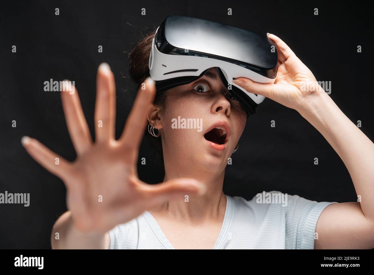Portrait of young had shocked screaming woman removing VR glasses and ...