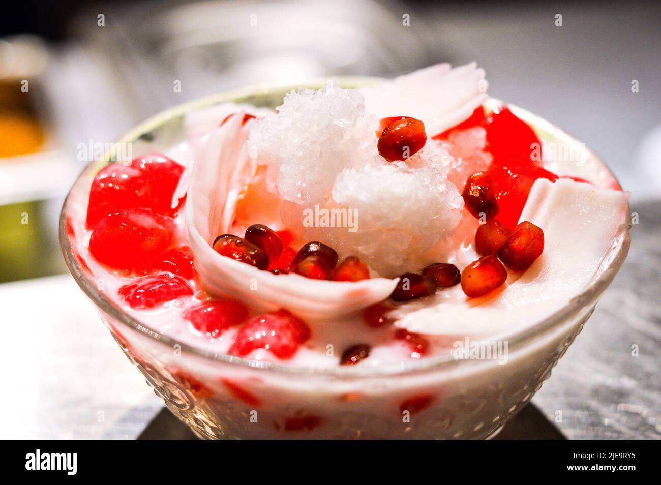 Coconut milk drink with coconut chips, ice, pomegranate and water ...