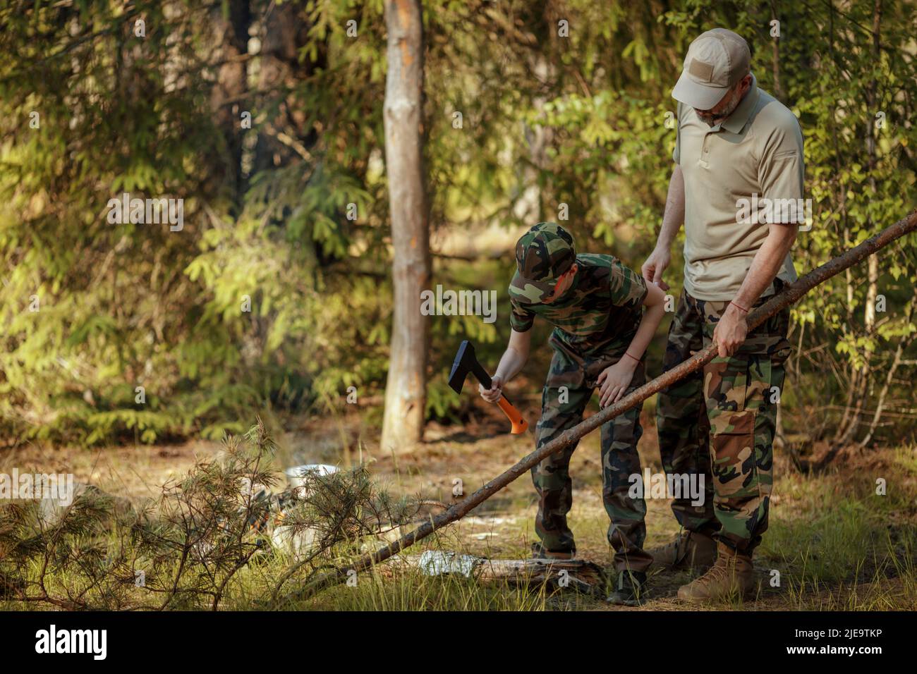 Father teaching his sun how to chop wood. The concept of adventure ...