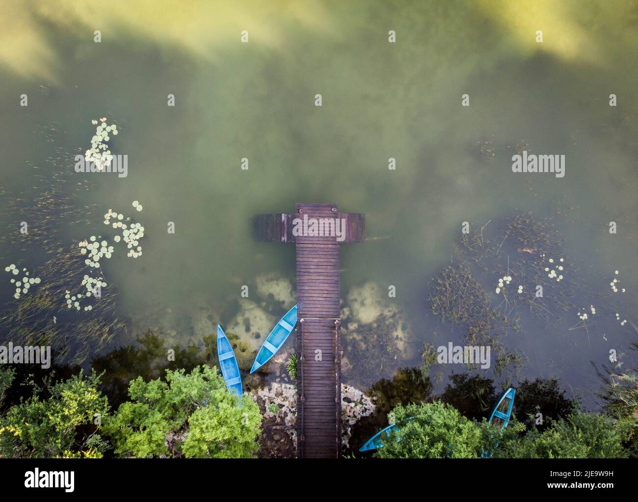 Aerial view of wooden deck with blue canoe in fresh water lagoon in the ...