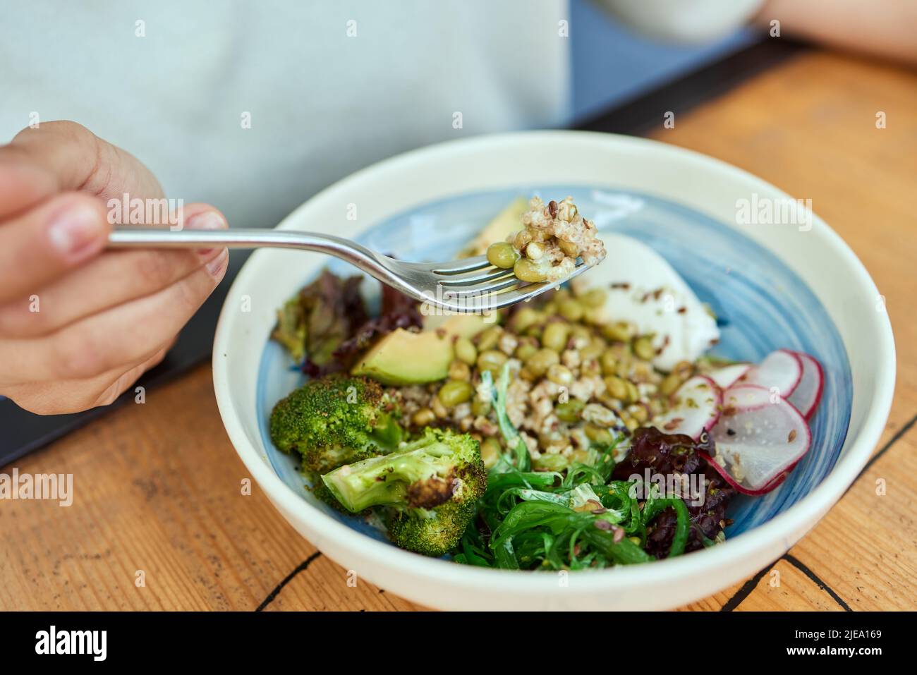 Woman eating quinoa broccoli salad. Eat healthy food lifestyle concept ...